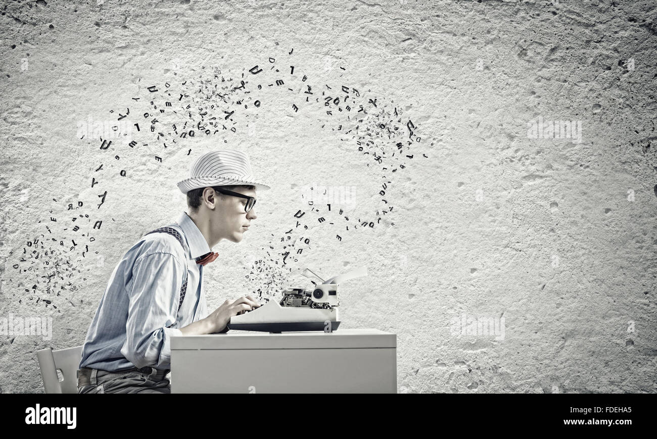 Young funny man in glasses writing on typewriter Stock Photo - Alamy