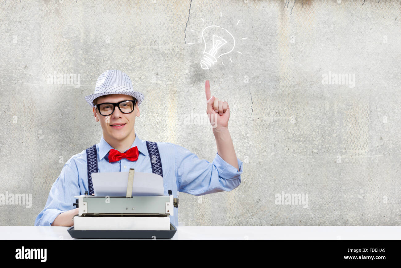 Young funny man in glasses writing on typewriter Stock Photo - Alamy