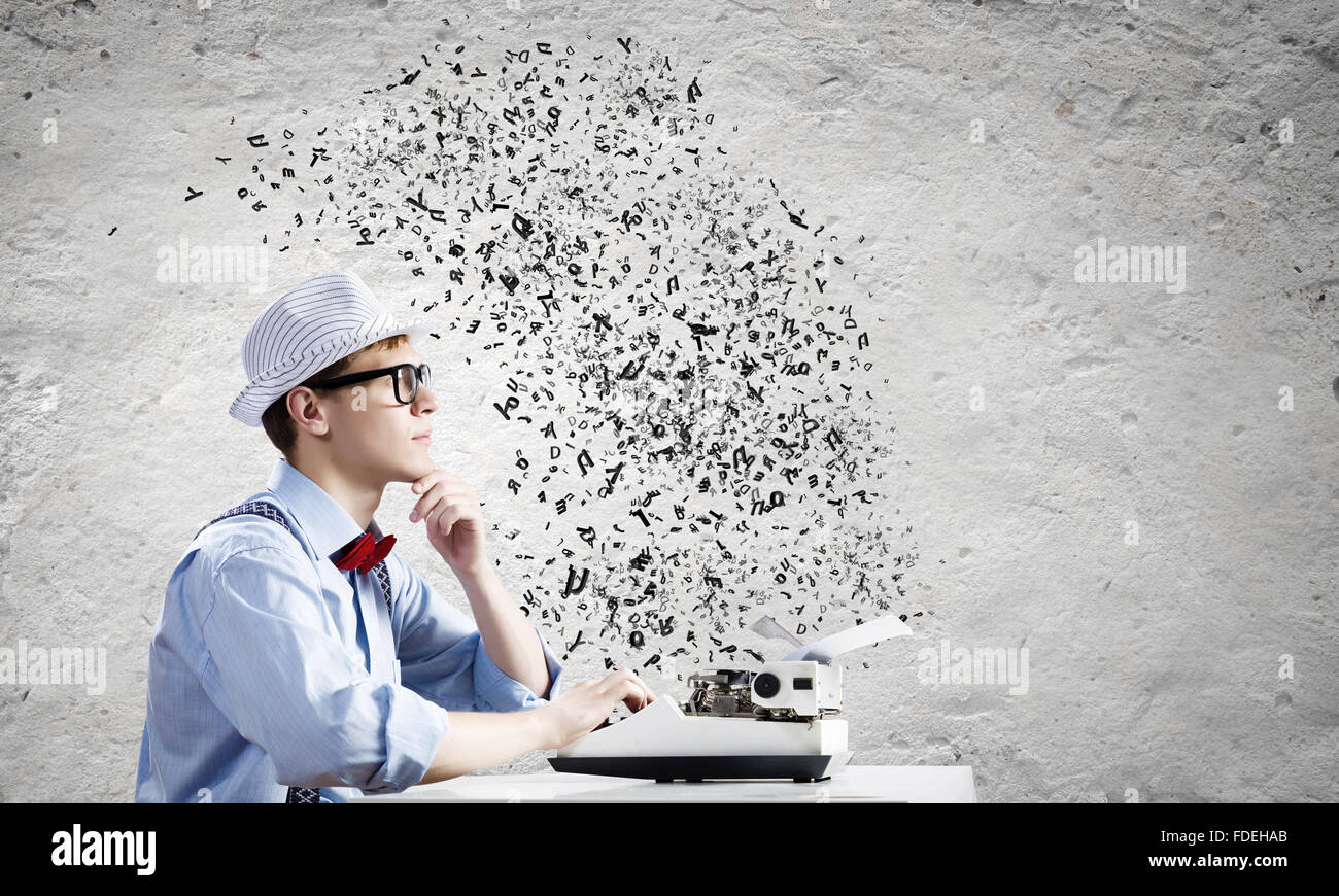 Young funny man in glasses writing on typewriter Stock Photo - Alamy