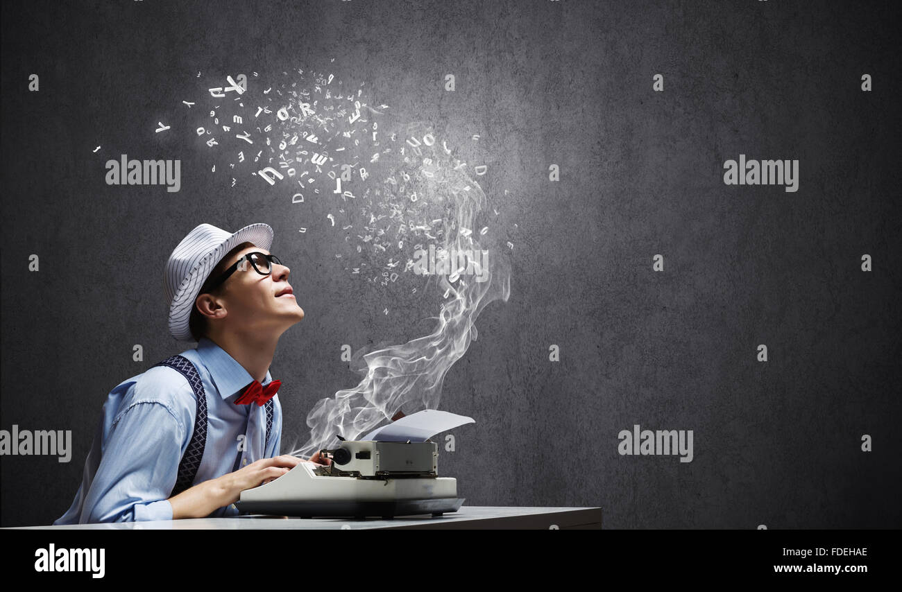 Young funny man in glasses writing on typewriter Stock Photo - Alamy