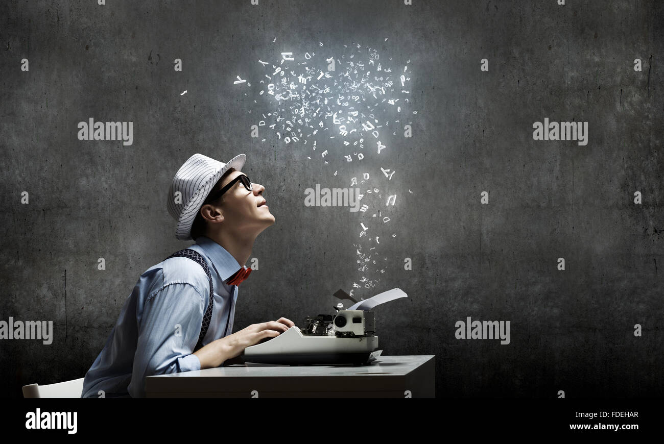 Young funny man in glasses writing on typewriter Stock Photo - Alamy