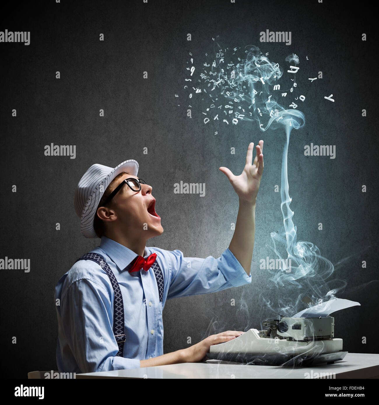 Young funny man in glasses writing on typewriter Stock Photo - Alamy
