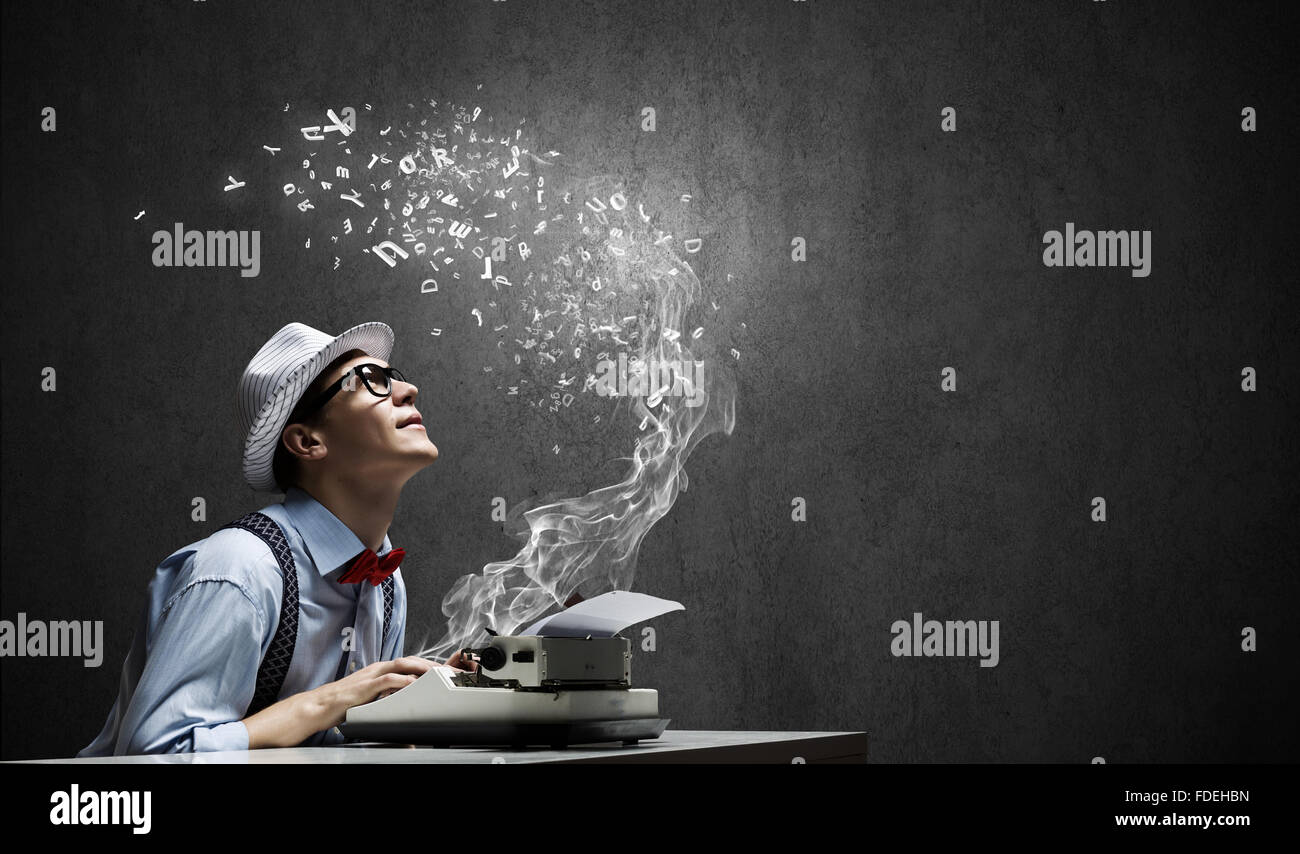 Young funny man in glasses writing on typewriter Stock Photo - Alamy