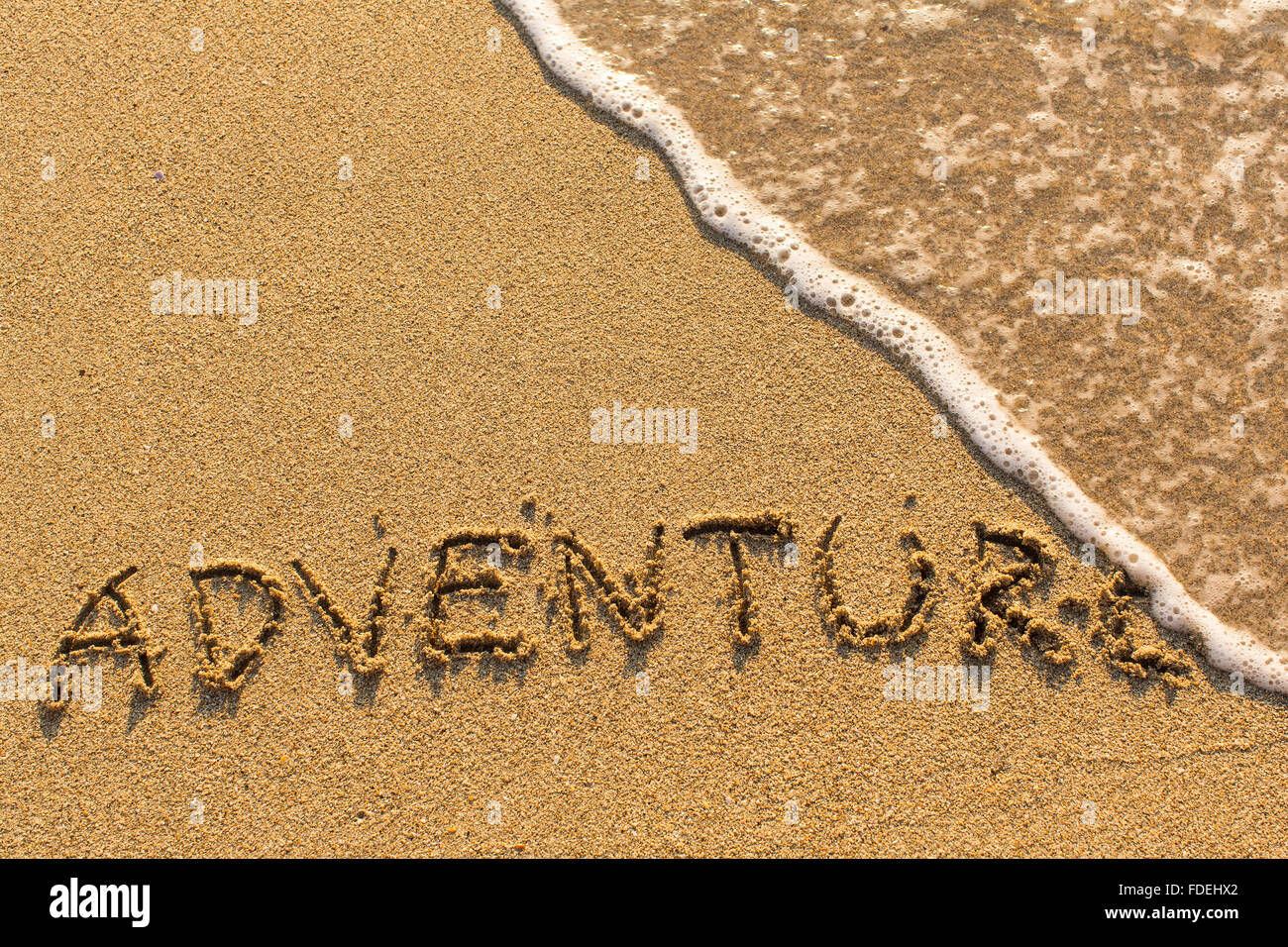 Adventure - word drawn on the sand beach with the soft wave Stock Photo ...