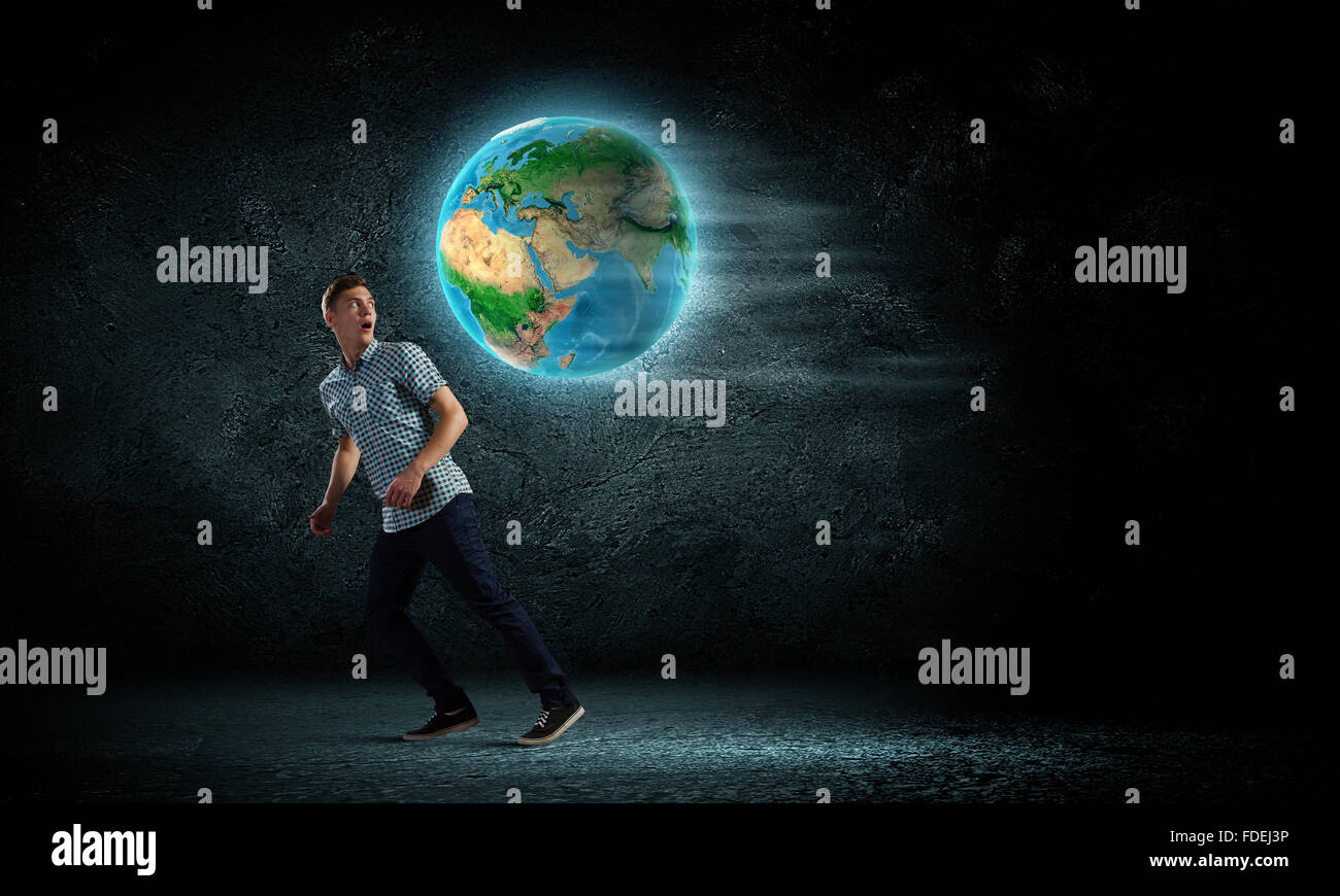 Young man against dark running from Earth planet. Elements of this ...