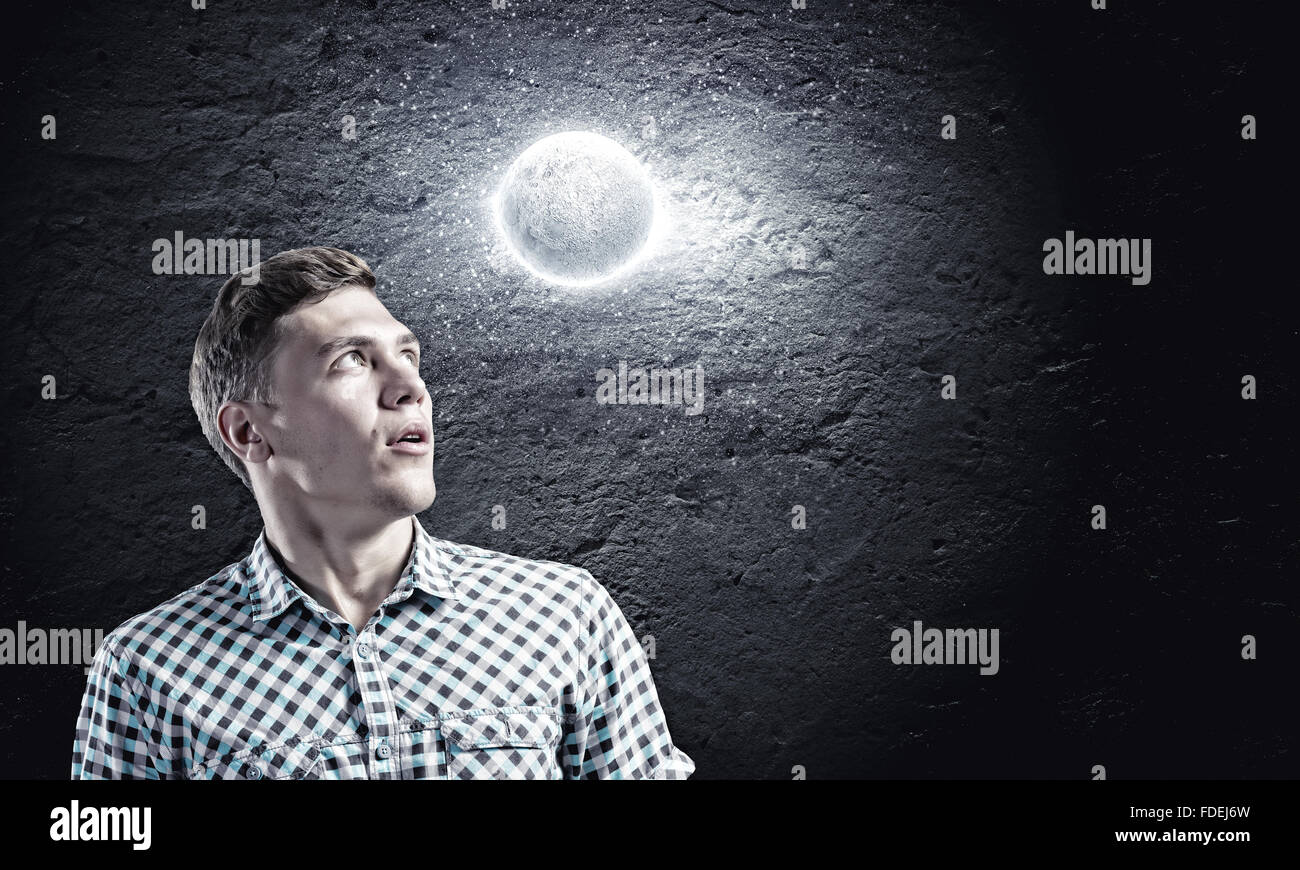 Young man and moon planet against dark background Stock Photo - Alamy