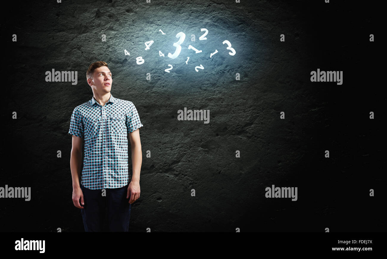 Young man and looking at numerals against dark background Stock Photo ...