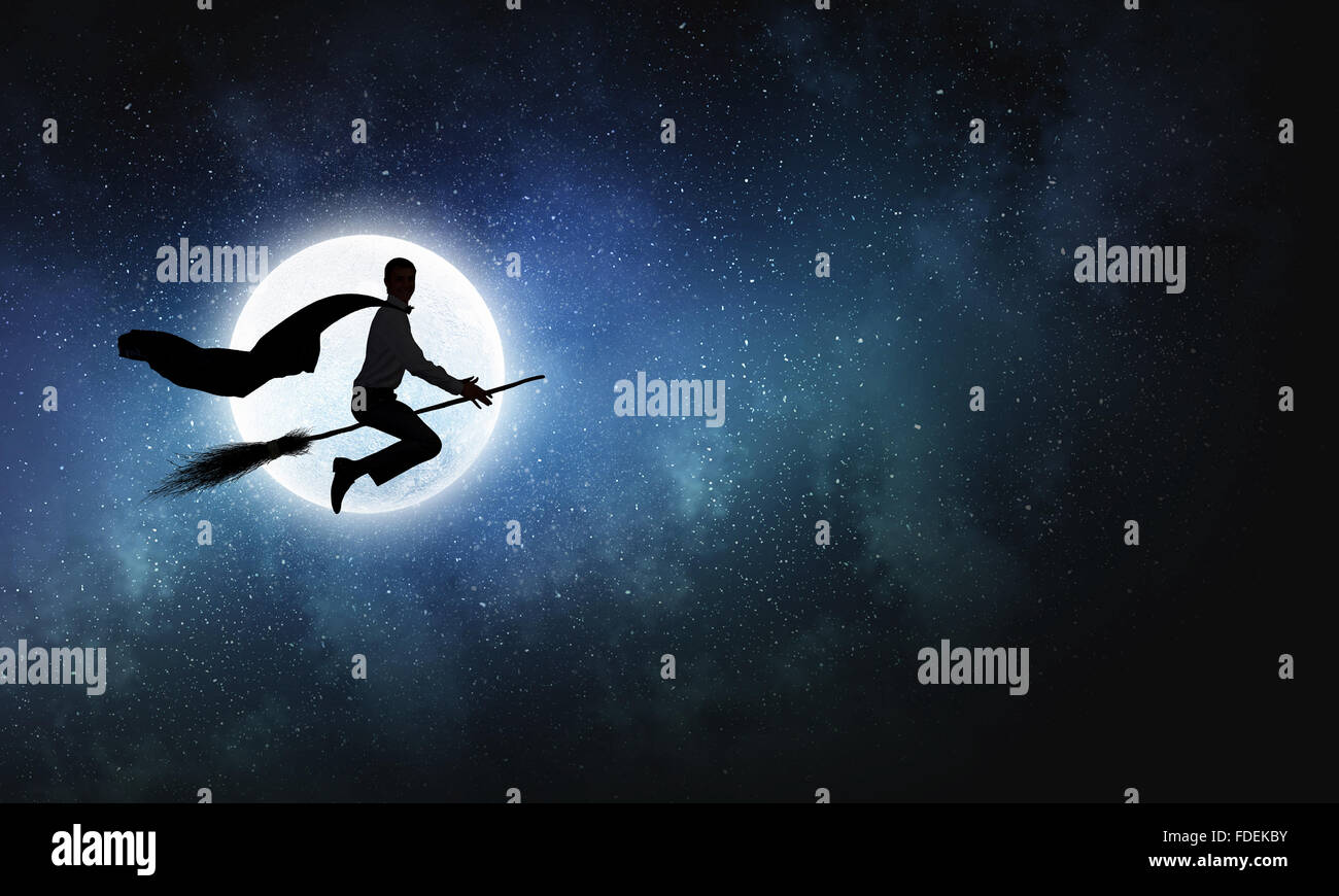 Young businessman flying on broom high in sky Stock Photo - Alamy