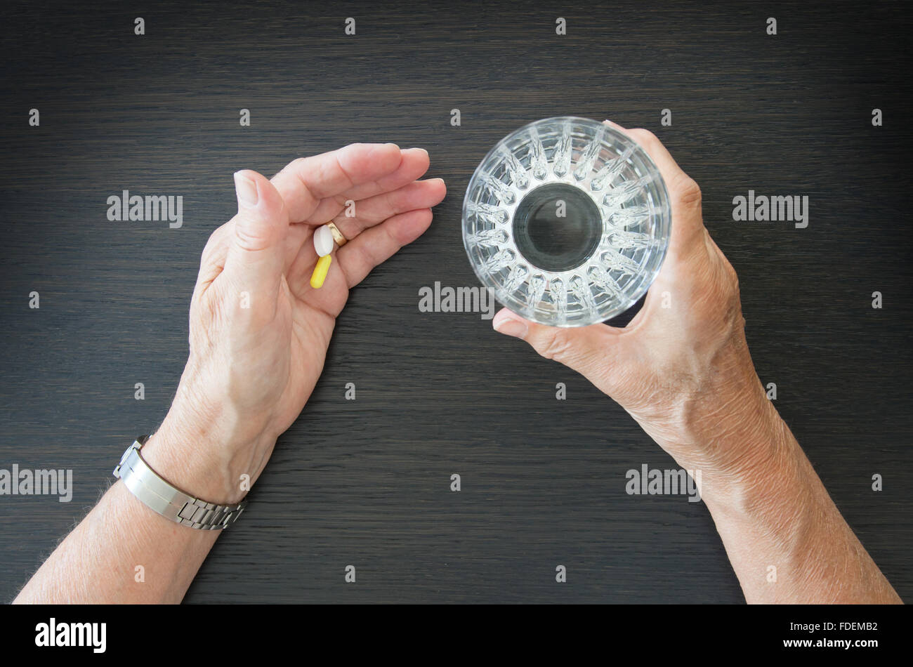 Elderly person taking medication, two different pills Stock Photo - Alamy