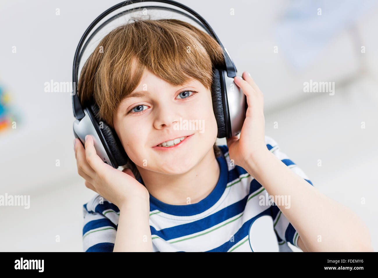 Cute boy wearing headphones and enjoying music Stock Photo - Alamy