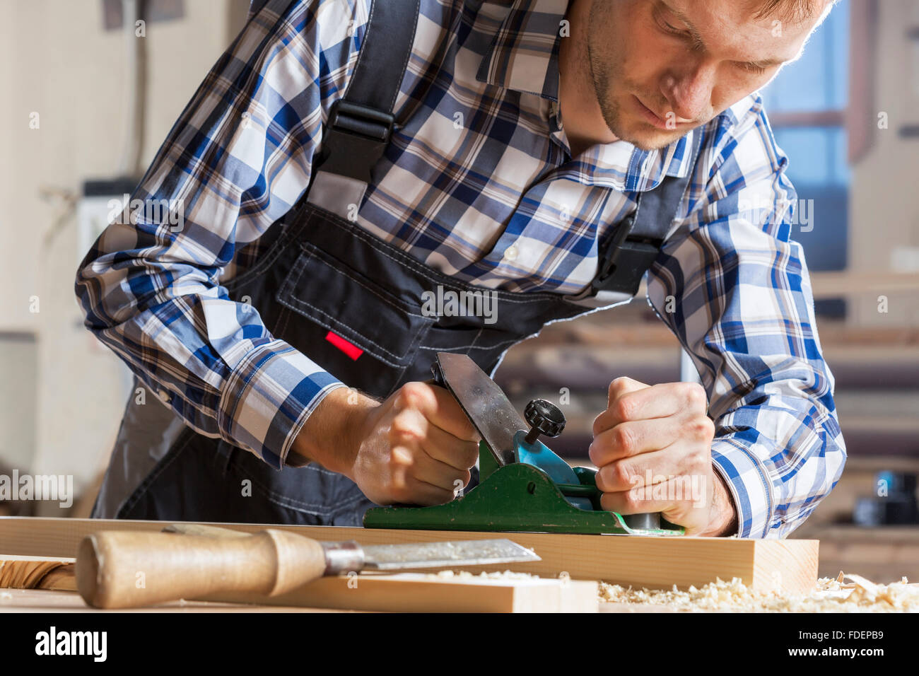 Carpenter working with plane in his studio Stock Photo - Alamy