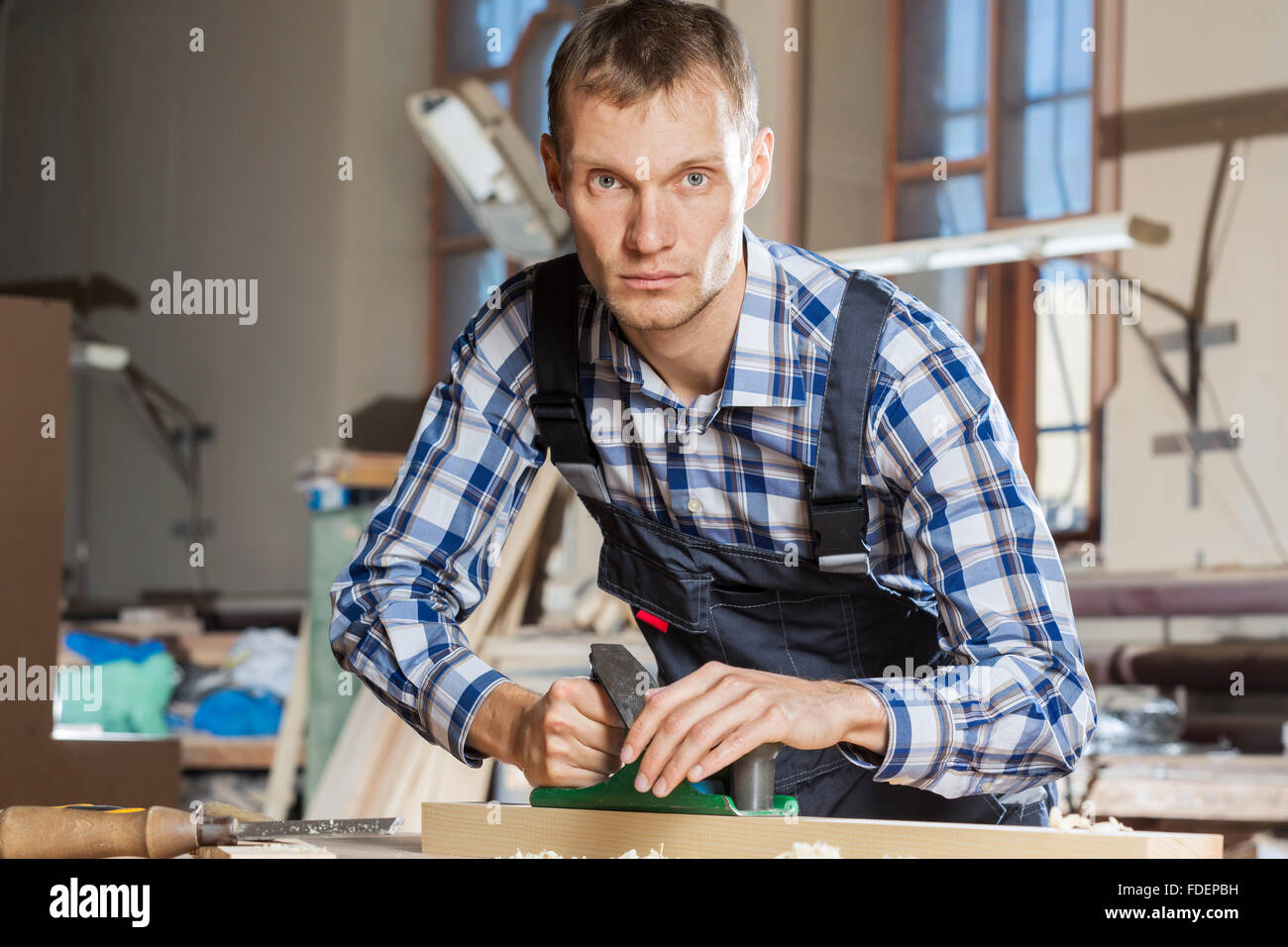Carpenter working with plane in his studio Stock Photo - Alamy