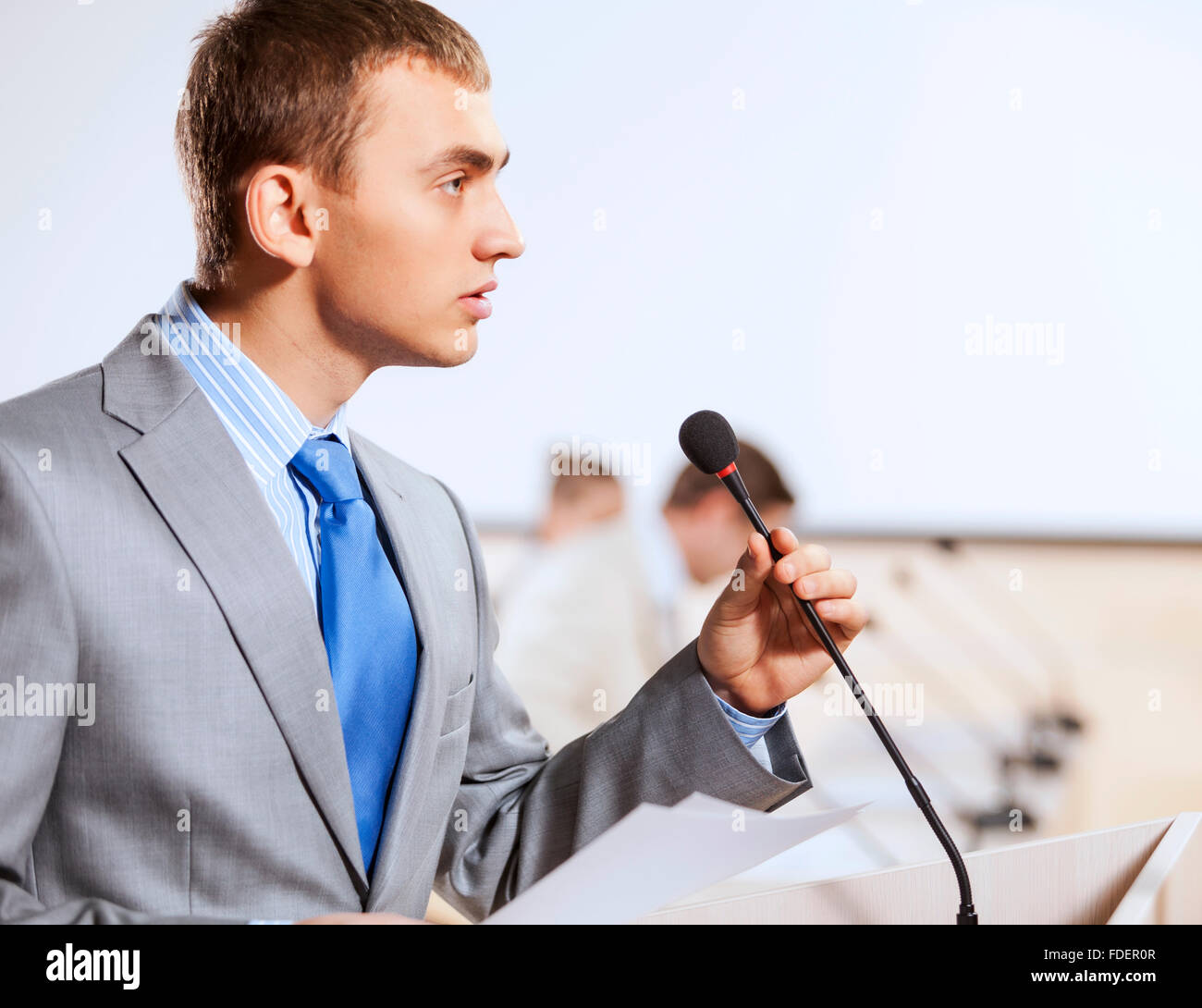 Businessman standing on stage and reporting for audience Stock Photo ...