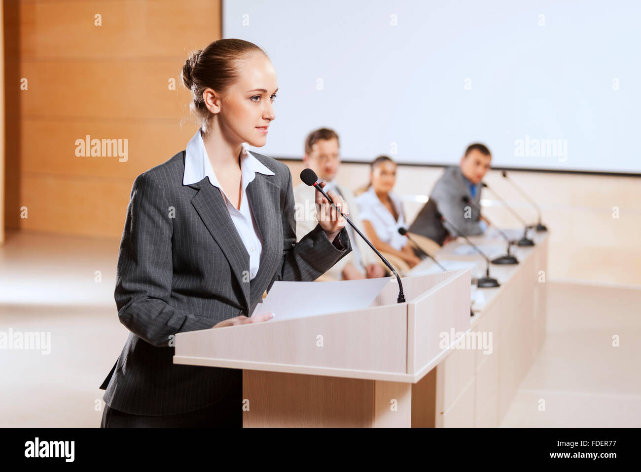 Businesswoman standing on stage and reporting for audience Stock Photo ...