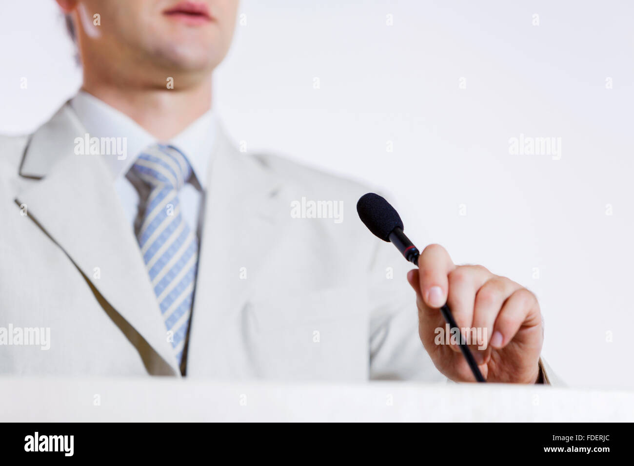 Young businessman standing on stage and speaking to microphone Stock ...