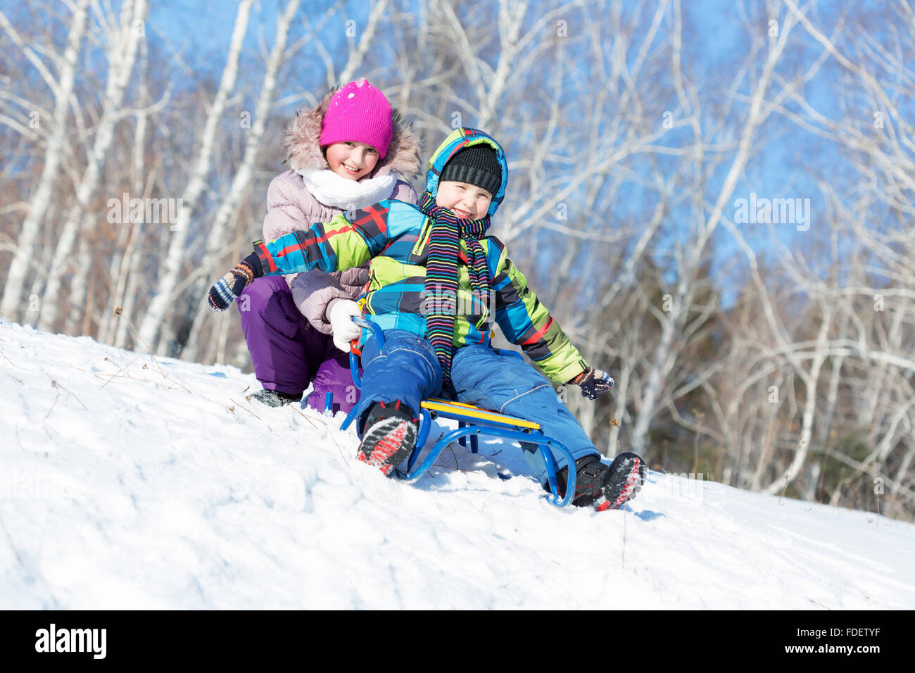 Boy and girl enjoying sledge ride in beautiful snowy winter park Stock ...
