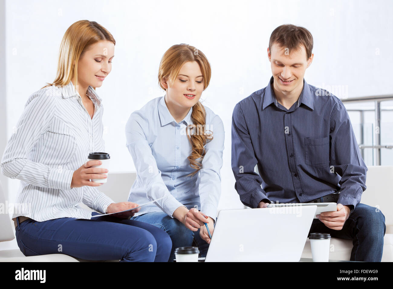 Three co-workers discussing business ideas in office Stock Photo - Alamy