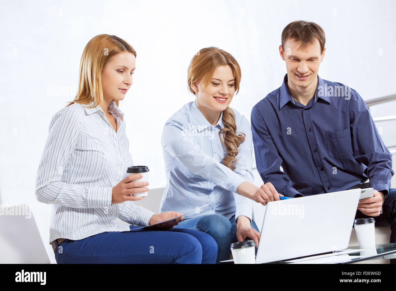 Three co-workers discussing business ideas in office Stock Photo - Alamy