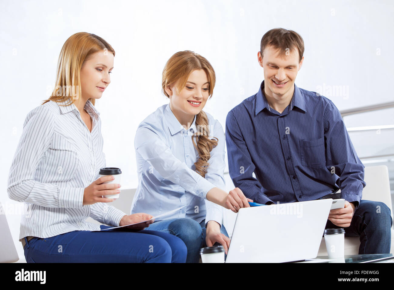 Three co-workers discussing business ideas in office Stock Photo - Alamy