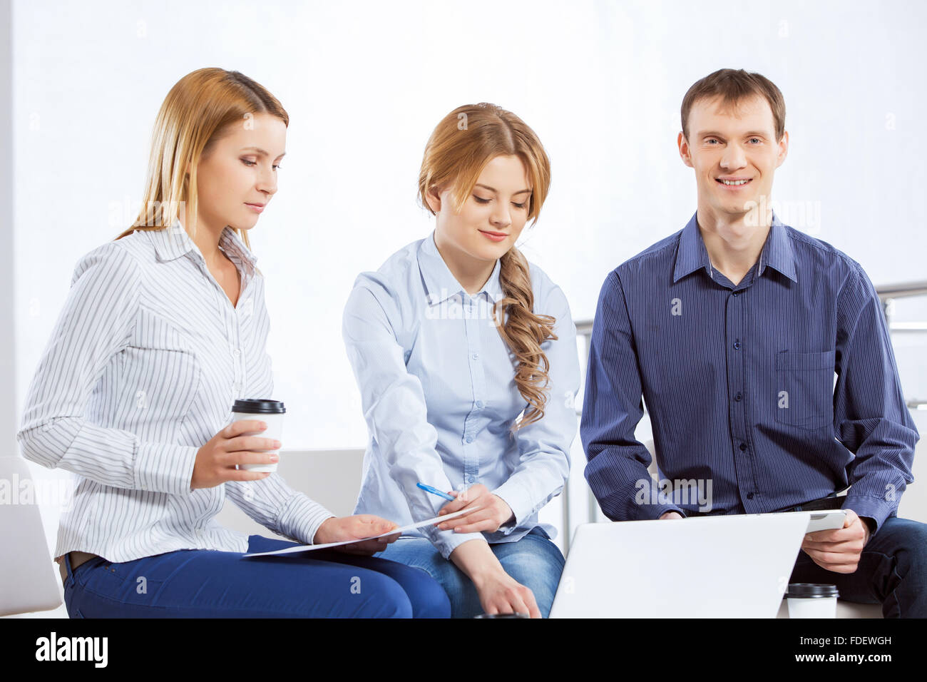 Three co-workers discussing business ideas in office Stock Photo - Alamy