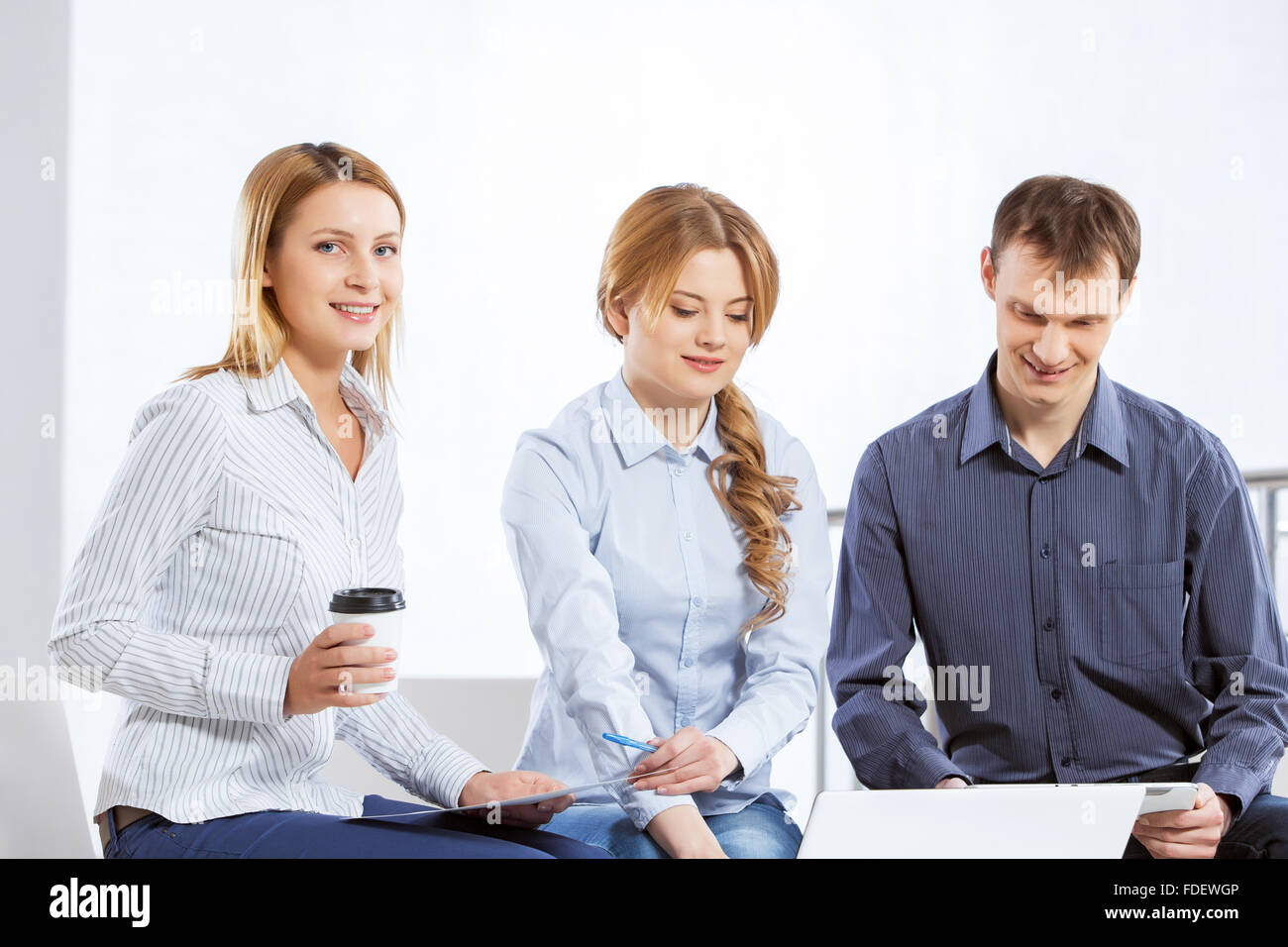 Three co-workers discussing business ideas in office Stock Photo - Alamy