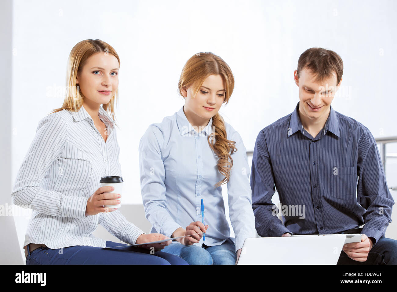 Three co-workers discussing business ideas in office Stock Photo - Alamy
