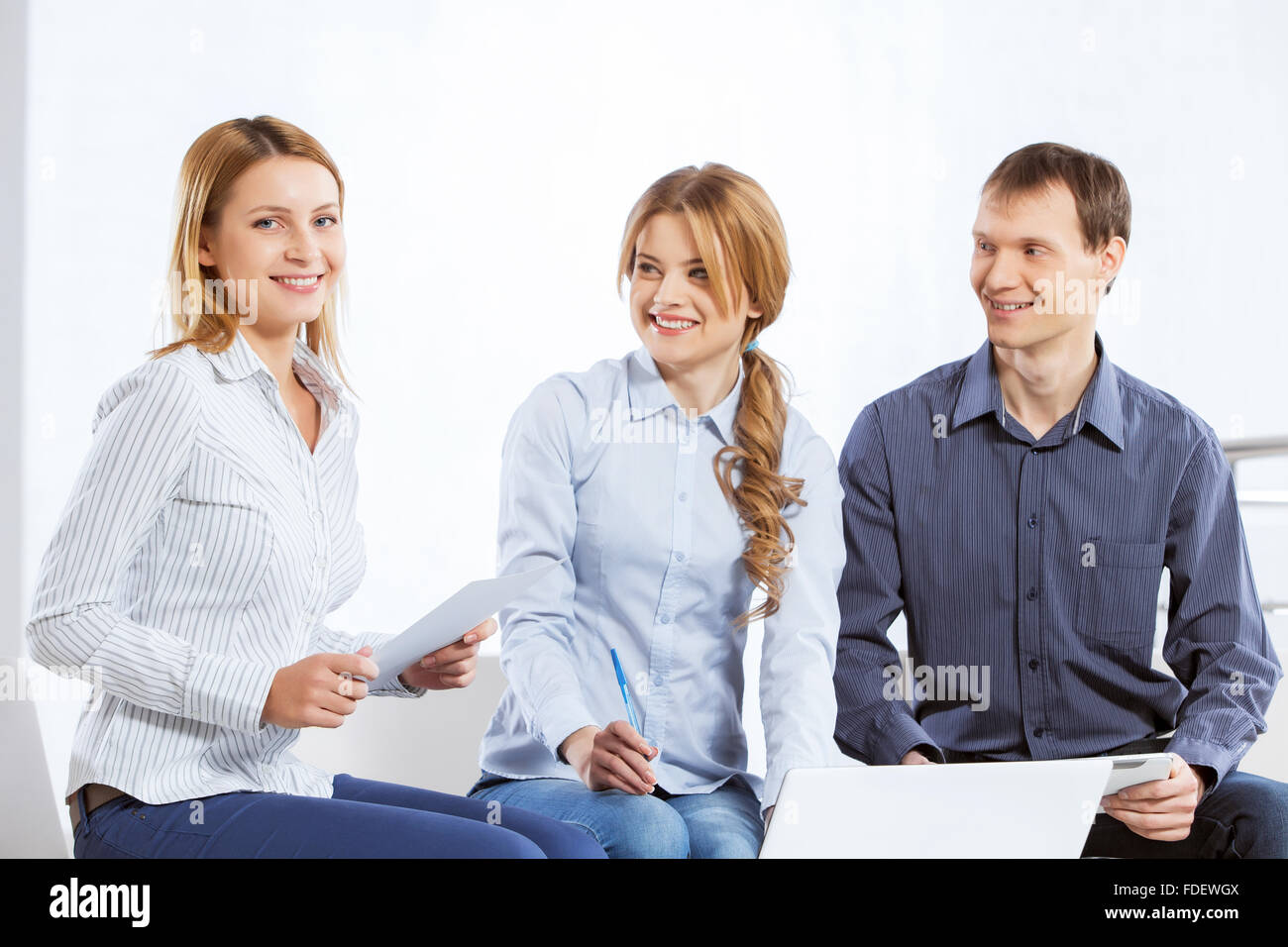 Three co-workers discussing business ideas in office Stock Photo - Alamy