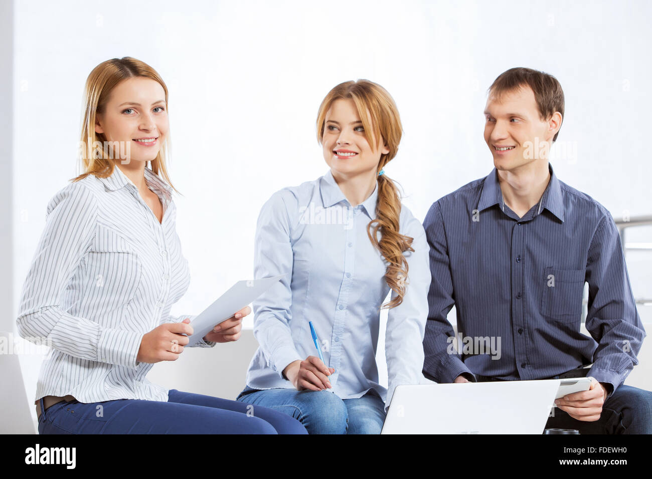 Three co-workers discussing business ideas in office Stock Photo - Alamy