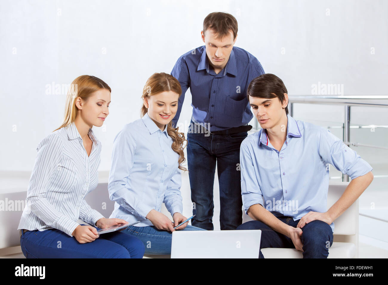 Four co-workers discussing business ideas in office Stock Photo - Alamy
