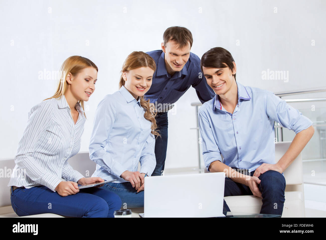 Four co-workers discussing business ideas in office Stock Photo - Alamy