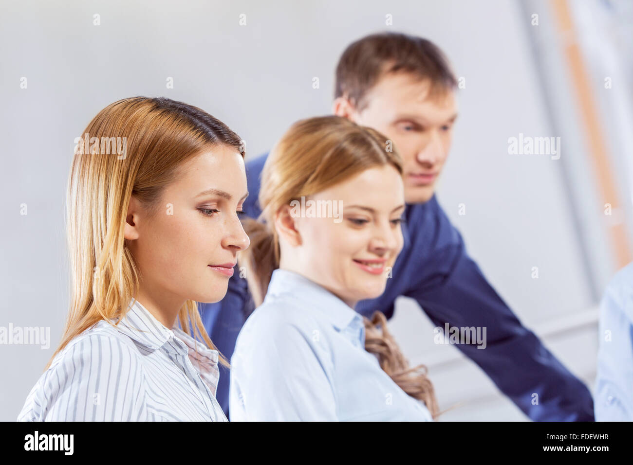 Three co-workers discussing business ideas in office Stock Photo - Alamy