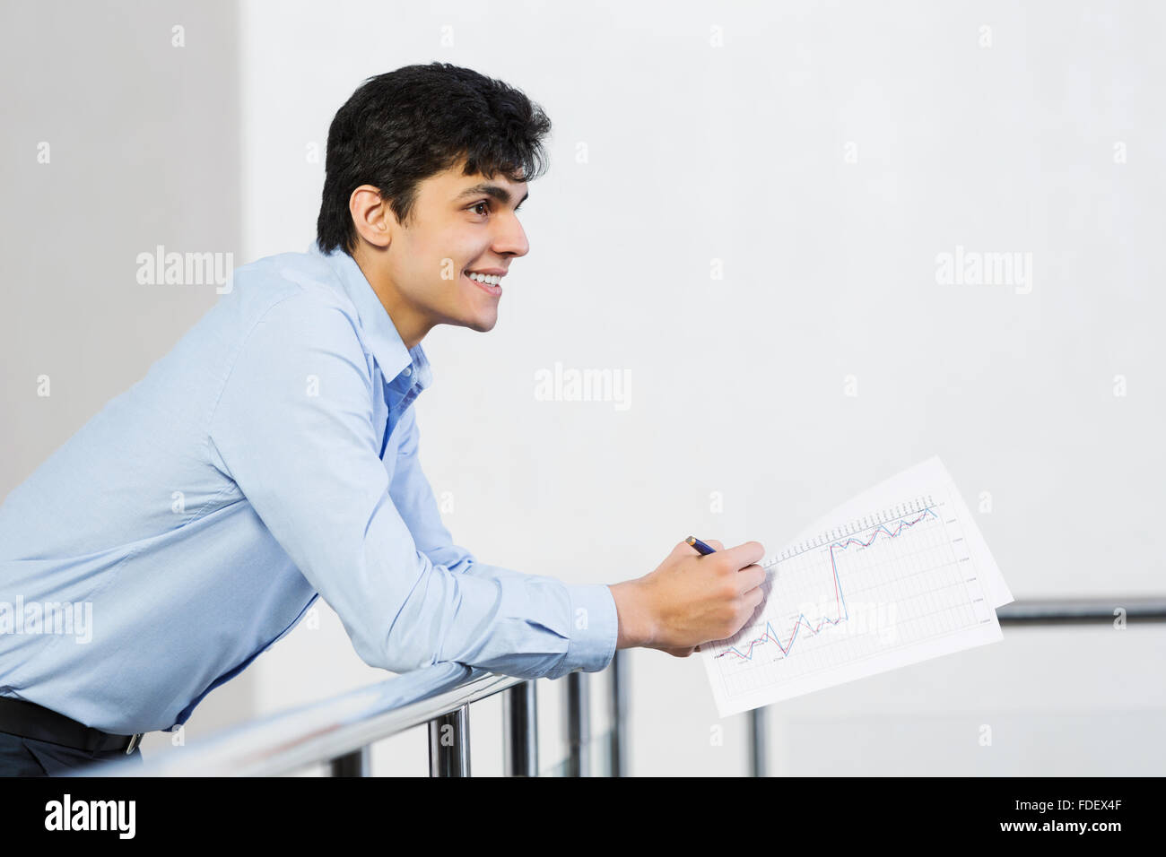 Handsome man standing on balcony with papers in hands Stock Photo - Alamy