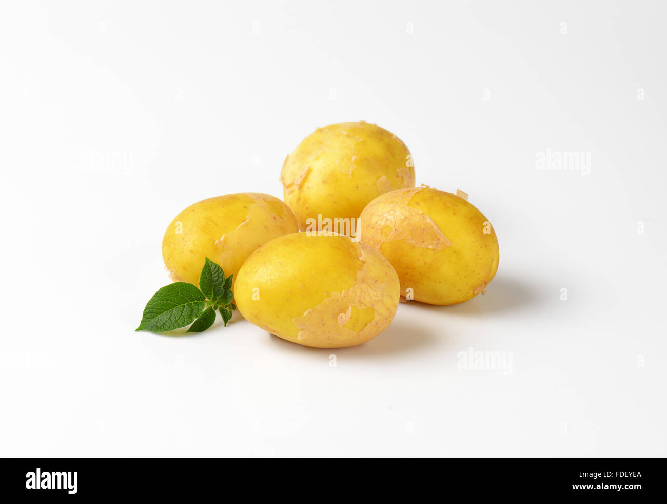 four baby potatoes with leaves on white background Stock Photo - Alamy