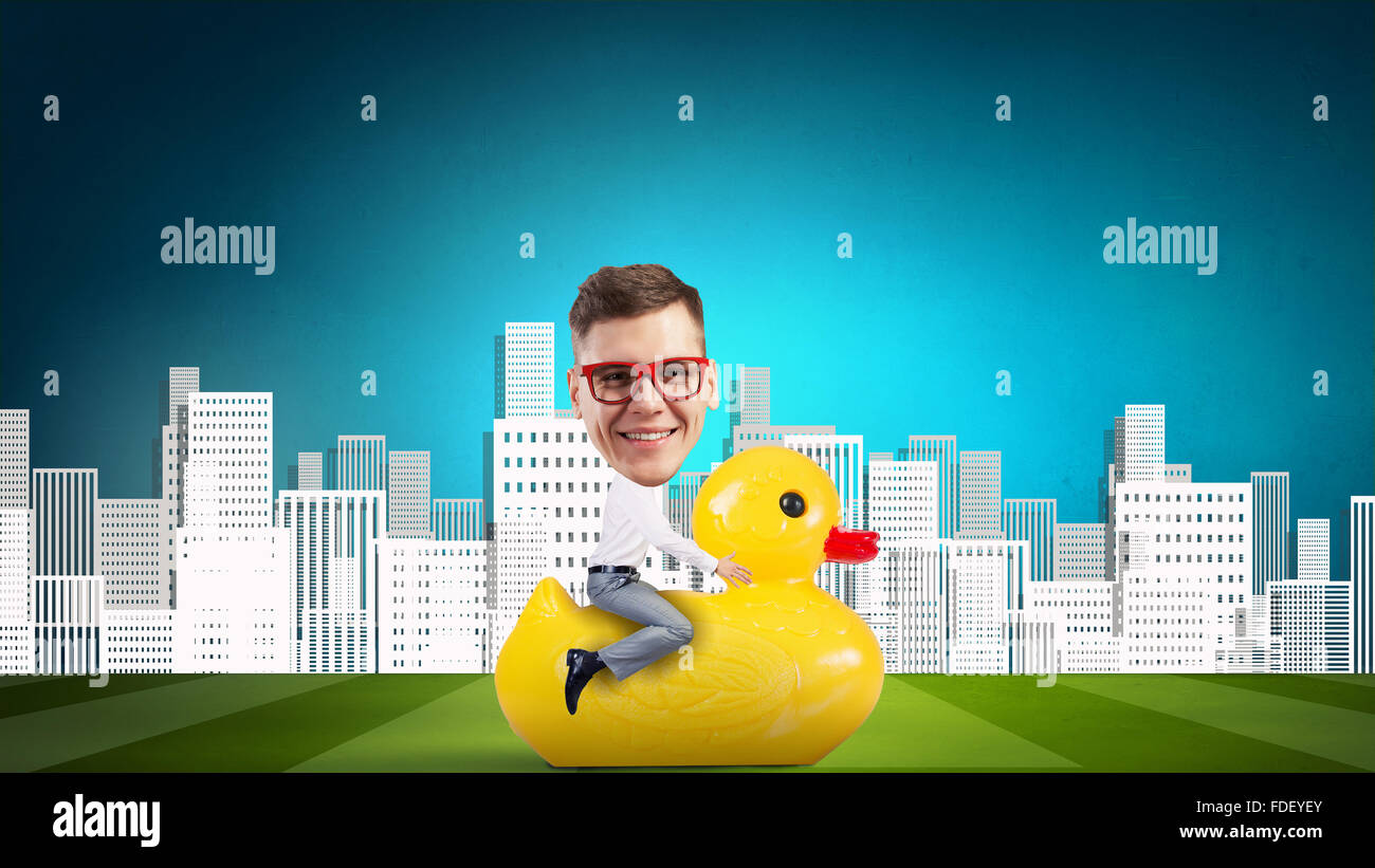 Young happy businessman riding yellow rubber duck Stock Photo - Alamy