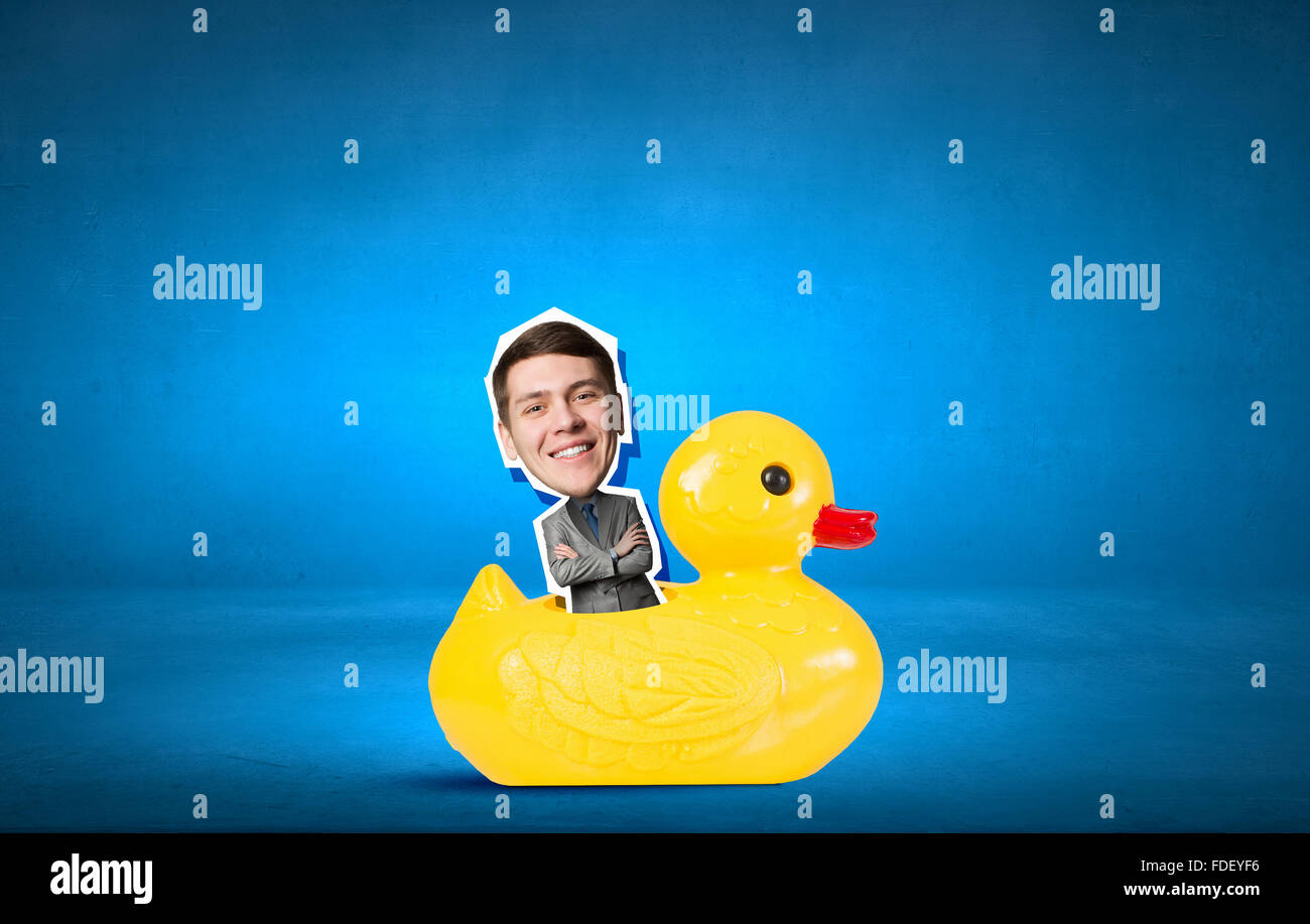 Young happy businessman riding yellow rubber duck Stock Photo - Alamy