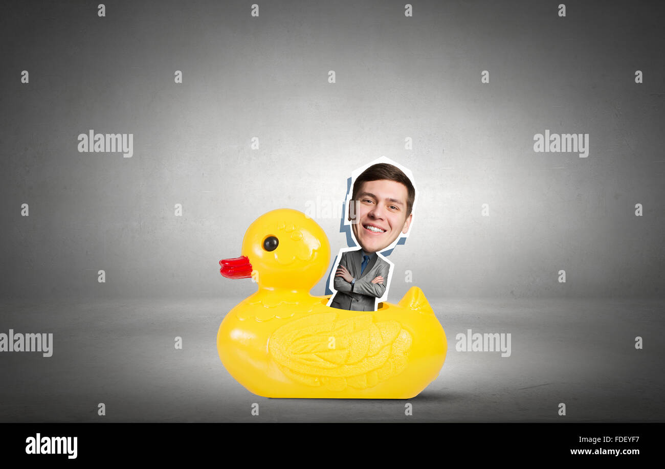 Young happy businessman riding yellow rubber duck Stock Photo - Alamy