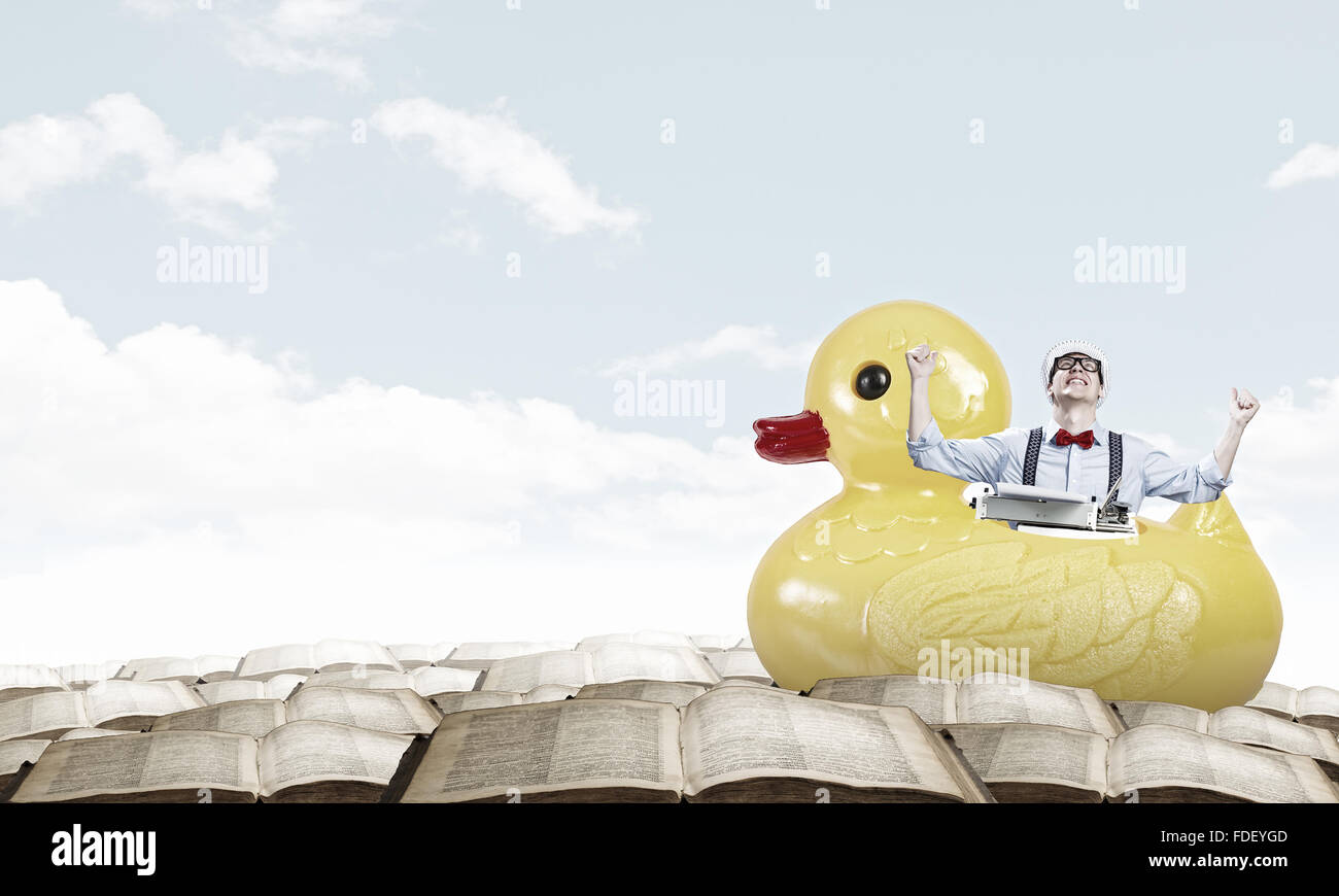 Young happy businessman riding yellow rubber duck Stock Photo - Alamy