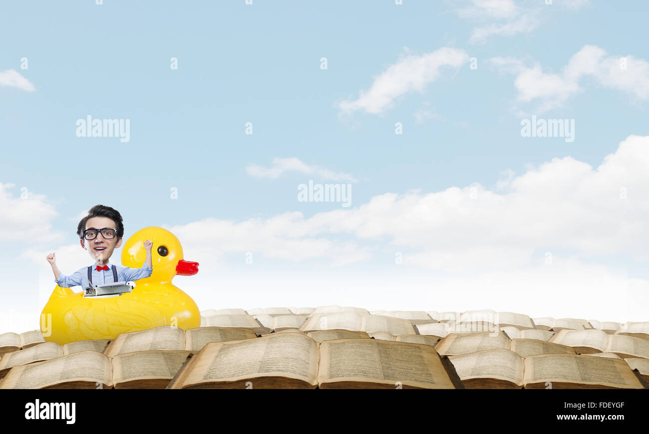 Young happy businessman riding yellow rubber duck Stock Photo - Alamy