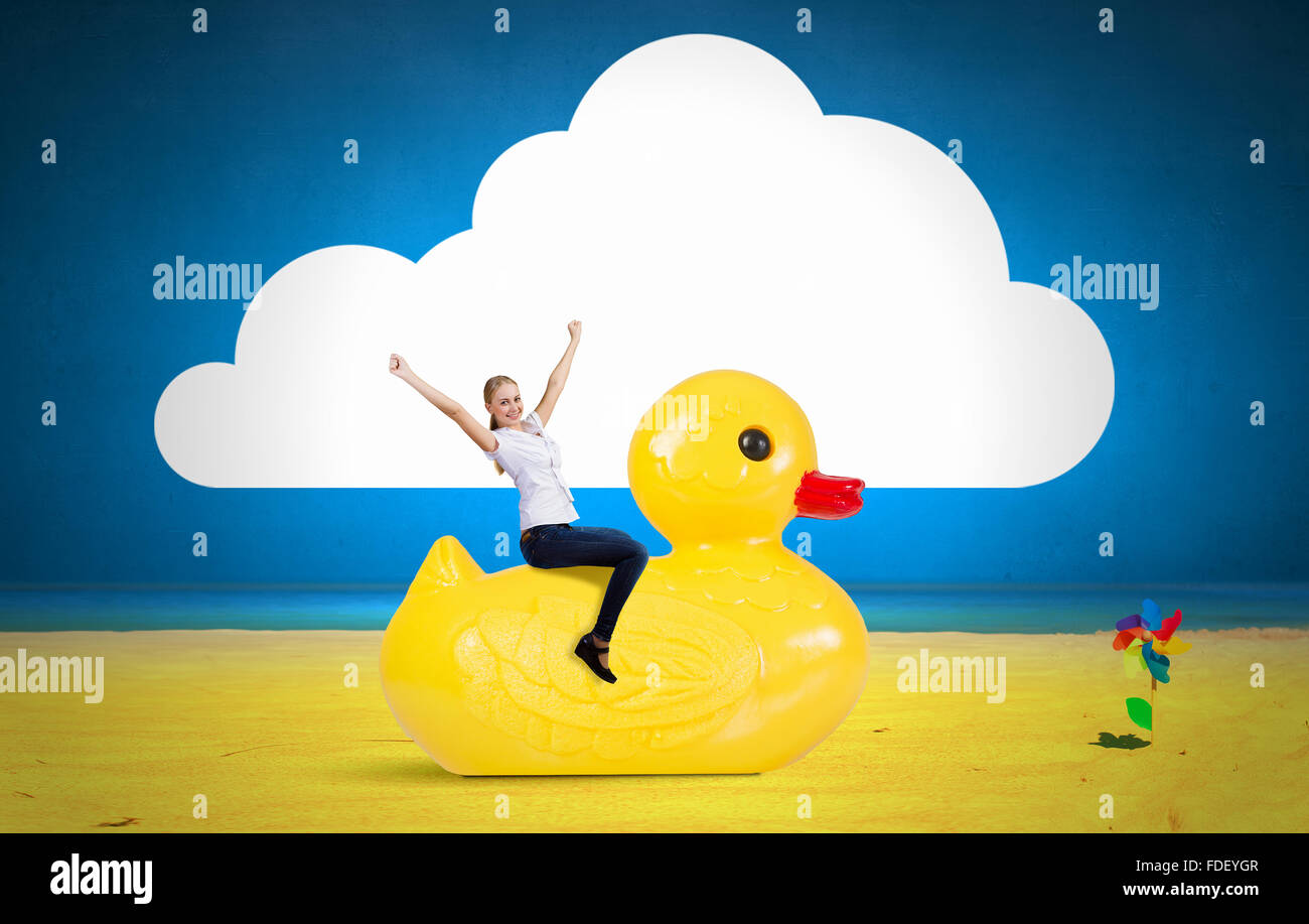 Young happy businesswoman riding yellow rubber duck Stock Photo - Alamy