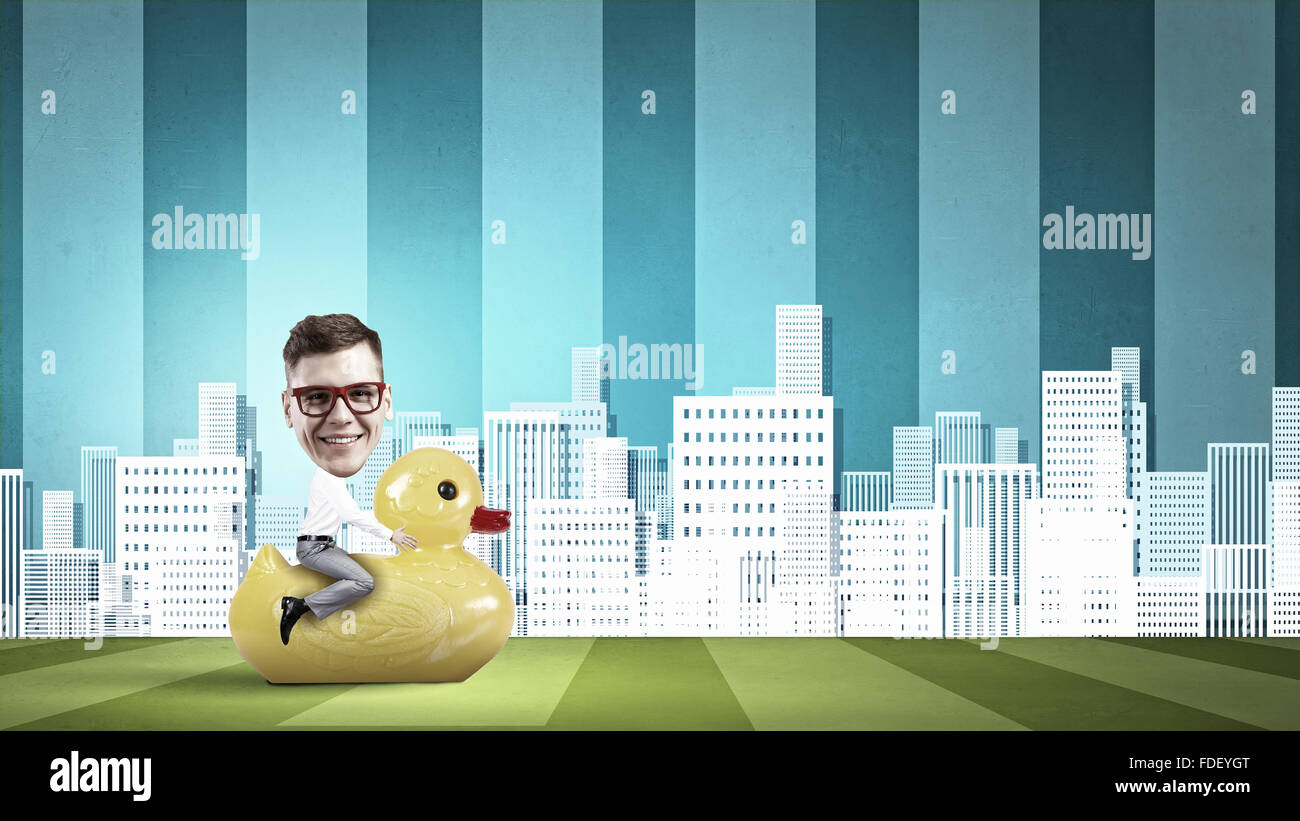 Young happy businessman riding yellow rubber duck Stock Photo - Alamy