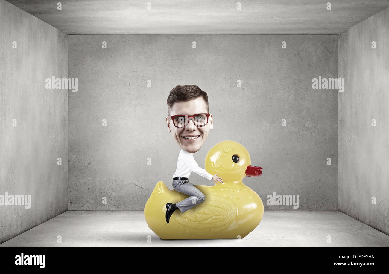 Young happy businessman riding yellow rubber duck Stock Photo - Alamy