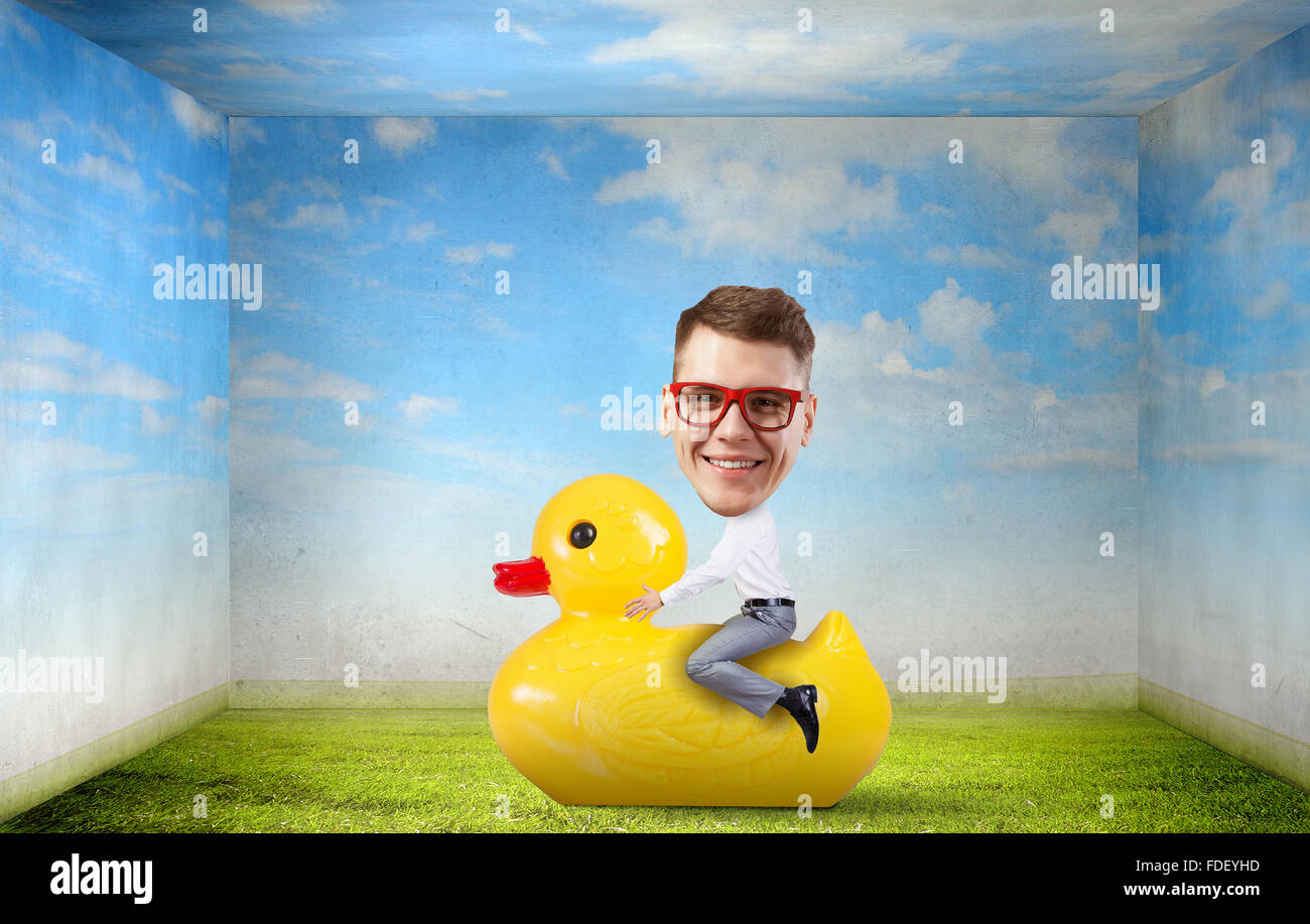 Young happy businessman riding yellow rubber duck Stock Photo - Alamy