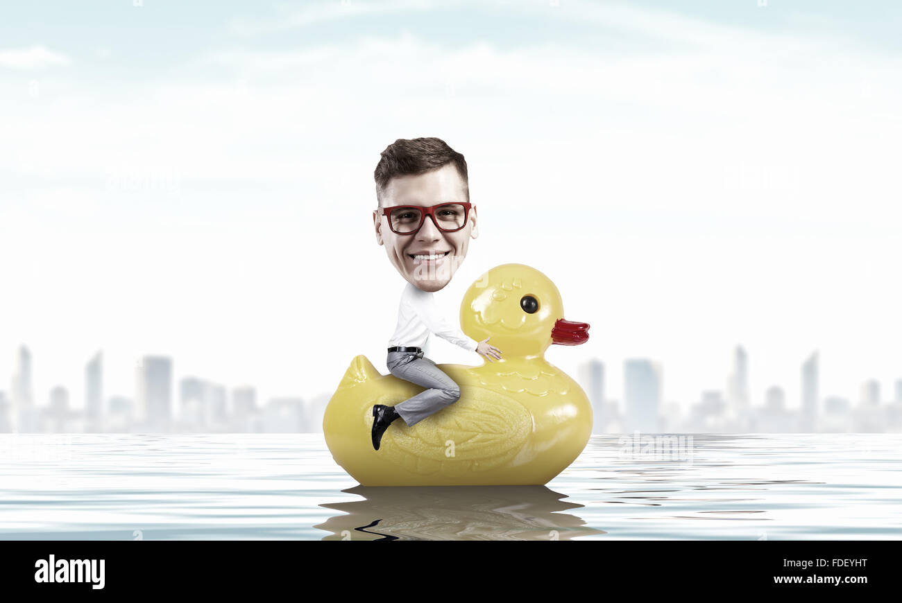 Young happy businessman riding yellow rubber duck Stock Photo - Alamy
