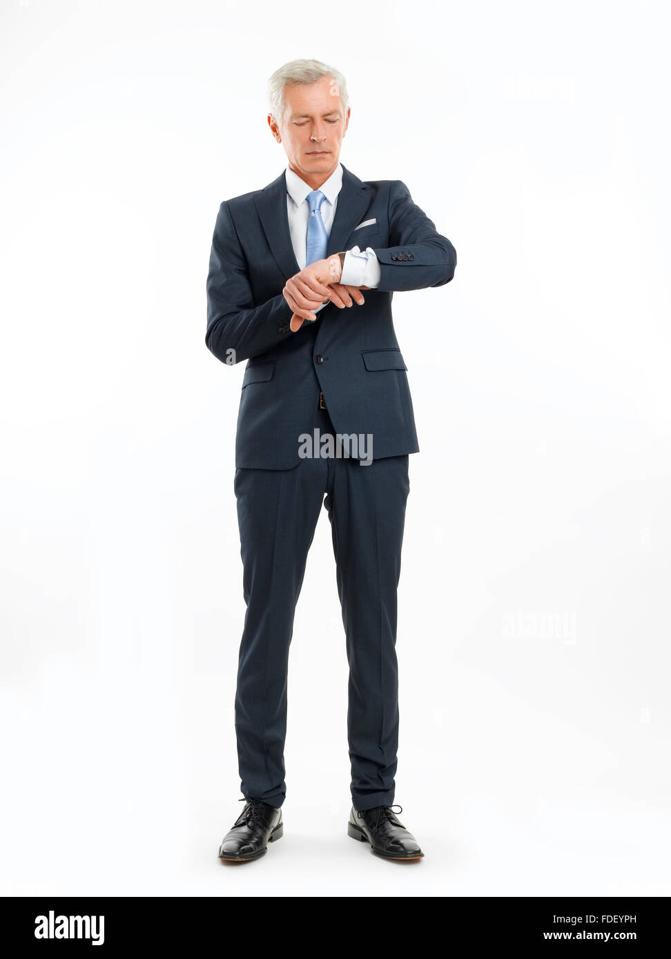 Portrait of busy sales man checking the time while standing against ...