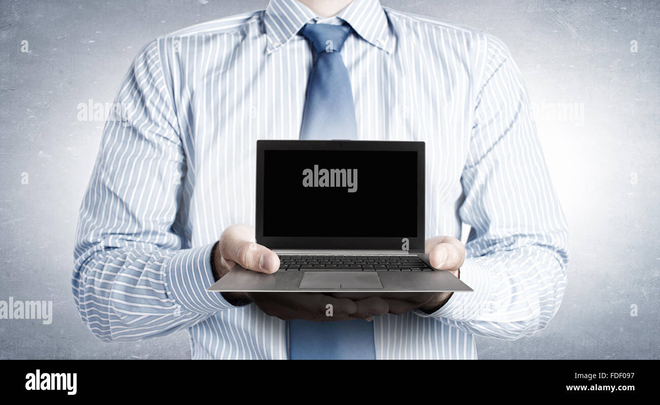 Close up of businessman's hands holding laptop Stock Photo - Alamy