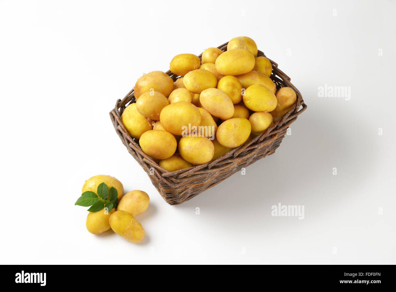 fresh baby potatoes in brown wicker basket on white background Stock ...