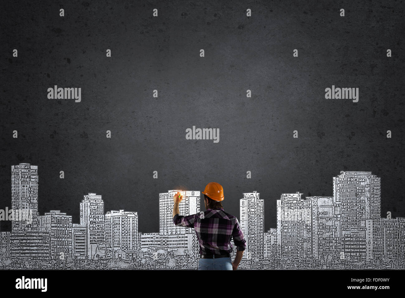 Back view of man engineer drawing building sketches on wall Stock Photo ...