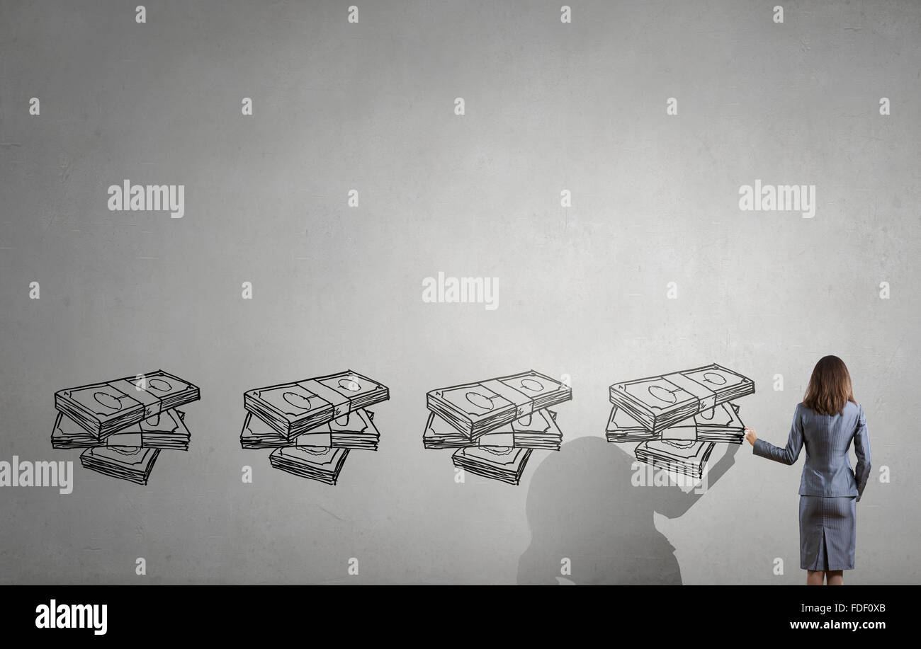 Back view of businesswoman drawing money banknotes on wall Stock Photo ...