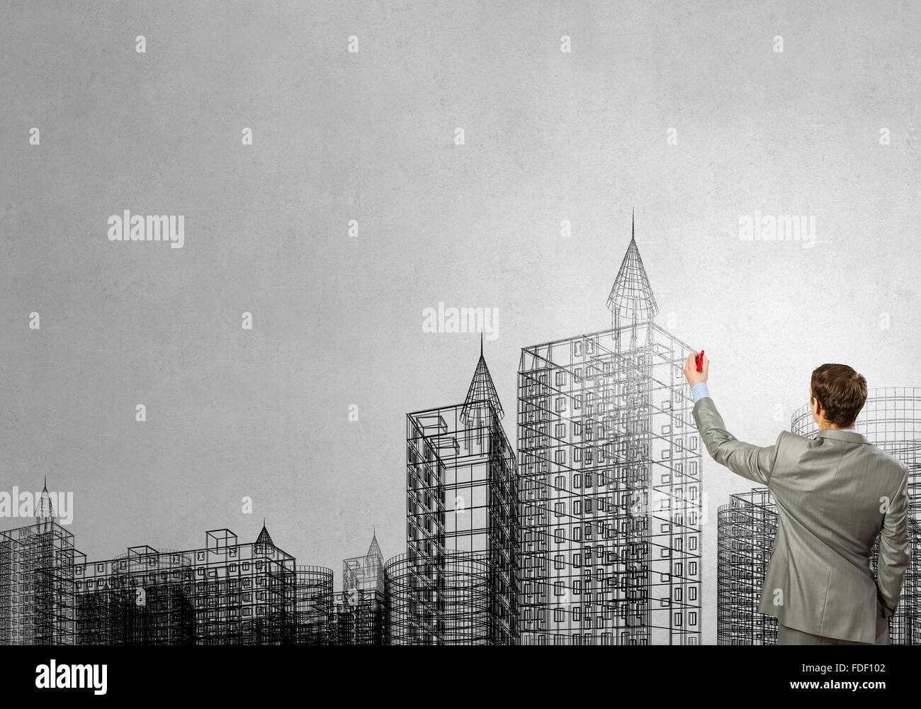 Back view of businessman drawing sketches of construction project on ...