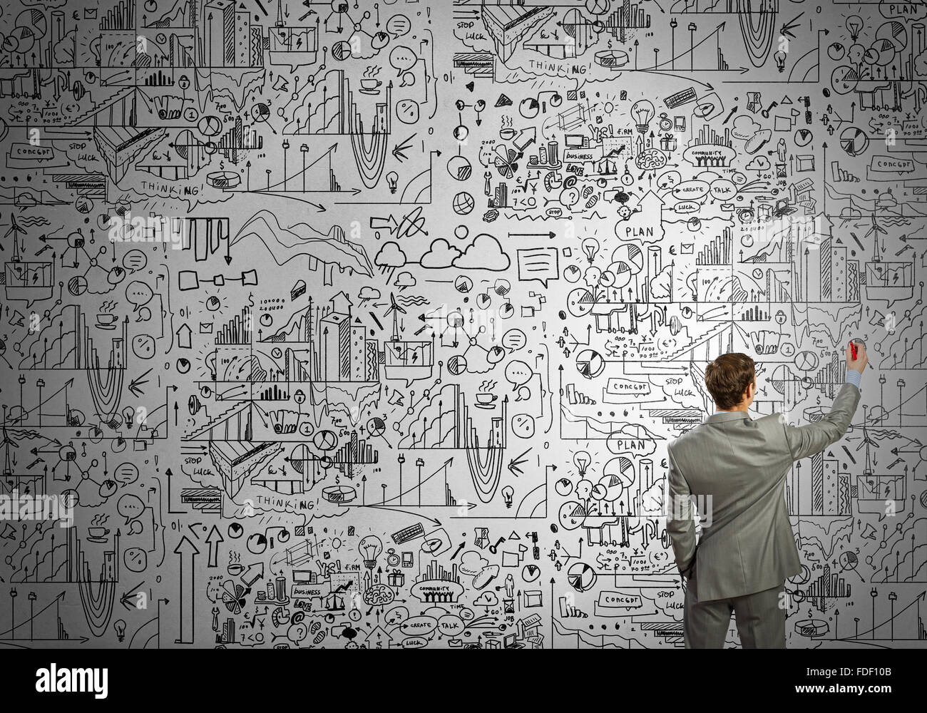 Rear view of businessman drawing business sketch on wall Stock Photo ...